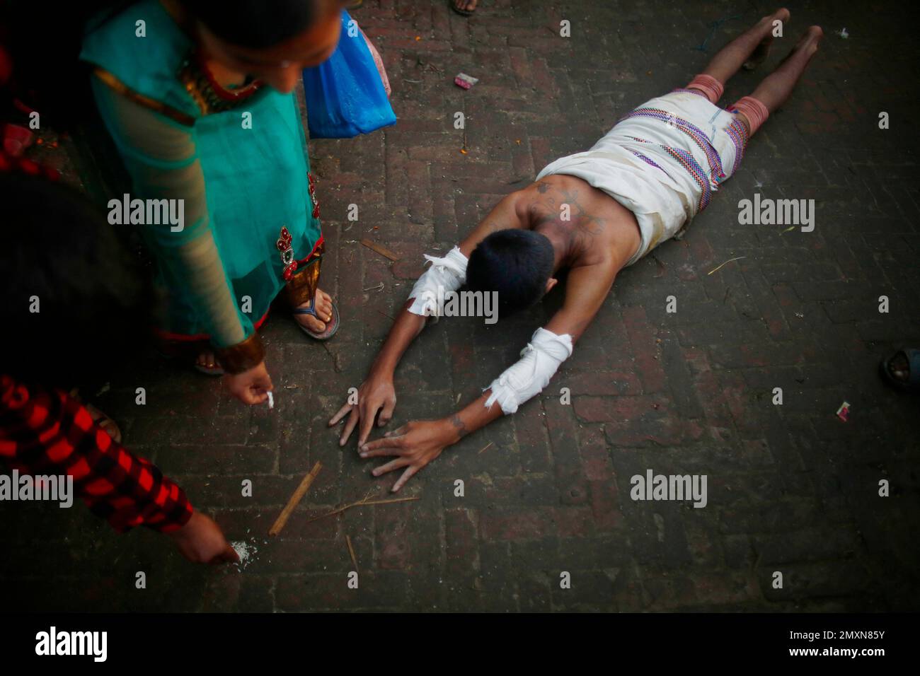 A Nepalese Hindu devotee prostrates on the ground to pray outside a ...