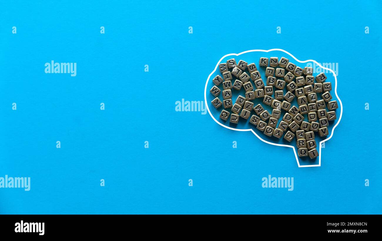 Brain shape and alphabet of a gold beads on blue background with copy ...