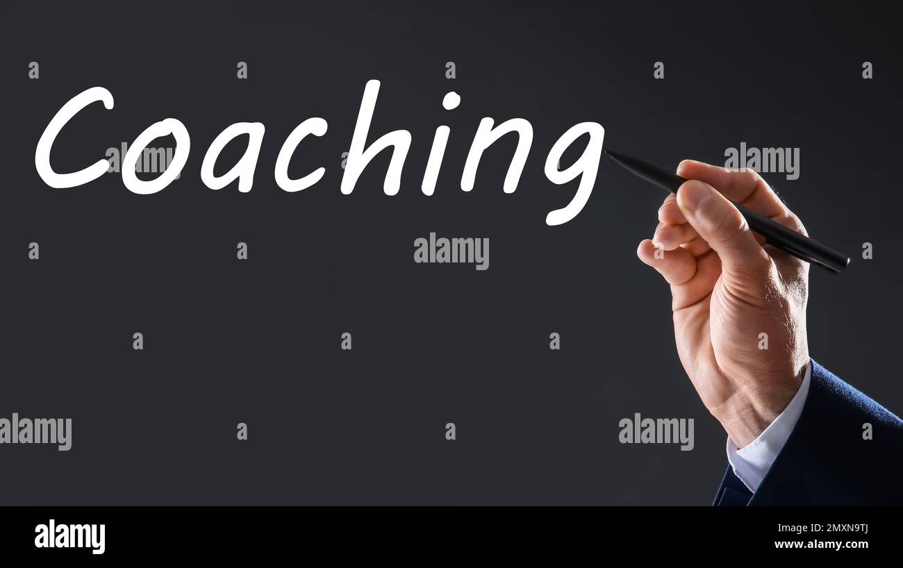 Business trainer writing word Coaching on virtual screen, closeup ...