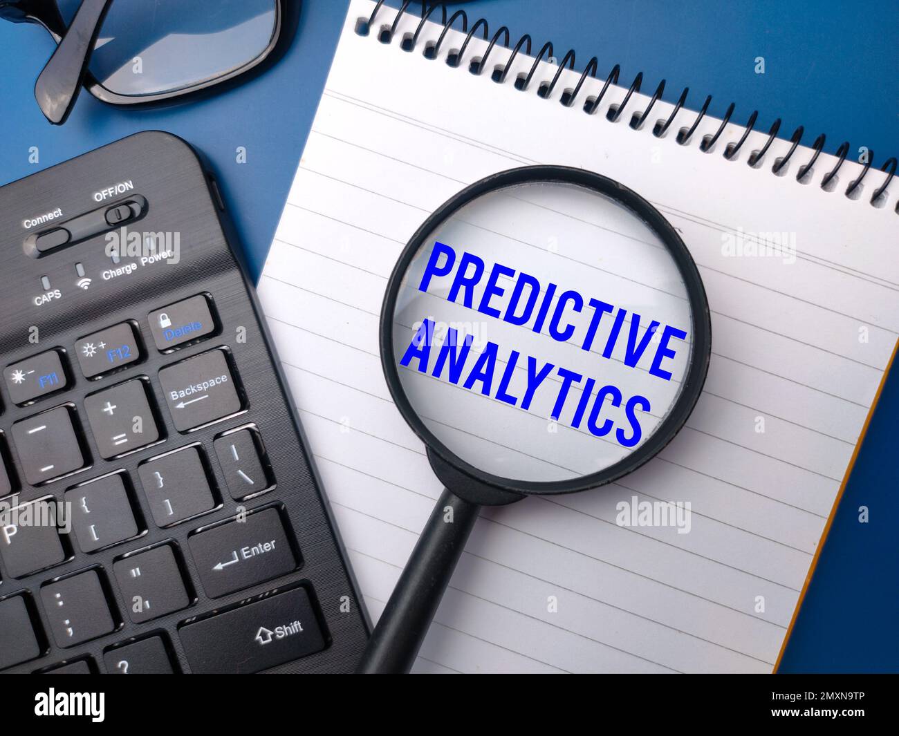 Wireless keyboard and magnifying glass with the word PREDICTIVE ...