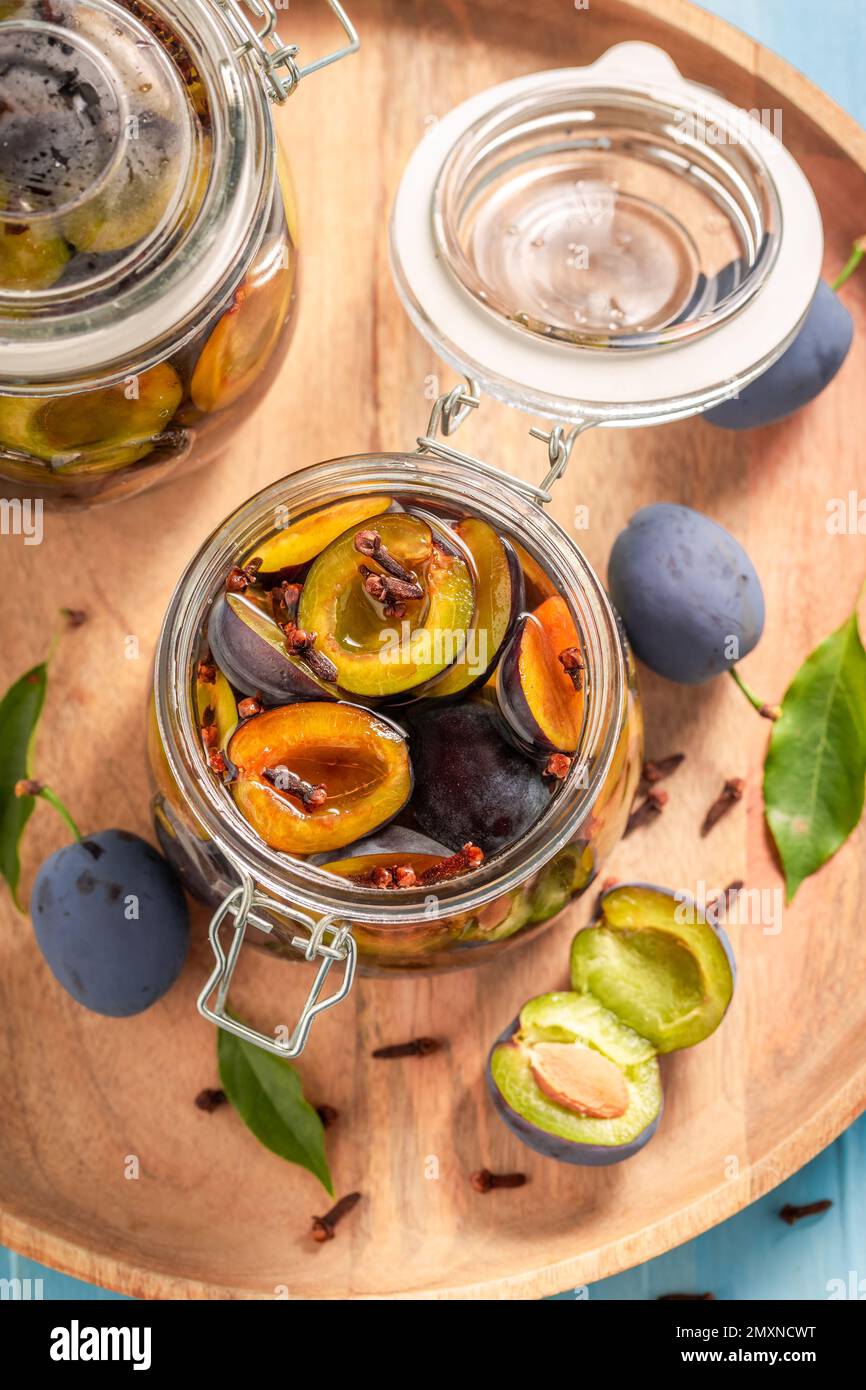 Sweet and tasty pickled plums in vinegar with cloves. Preserved fruits ...