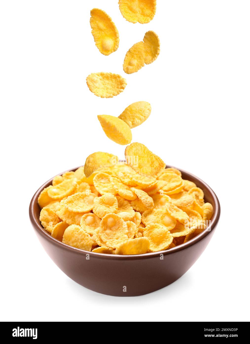 Tasty crispy corn flakes falling into bowl on white background ...