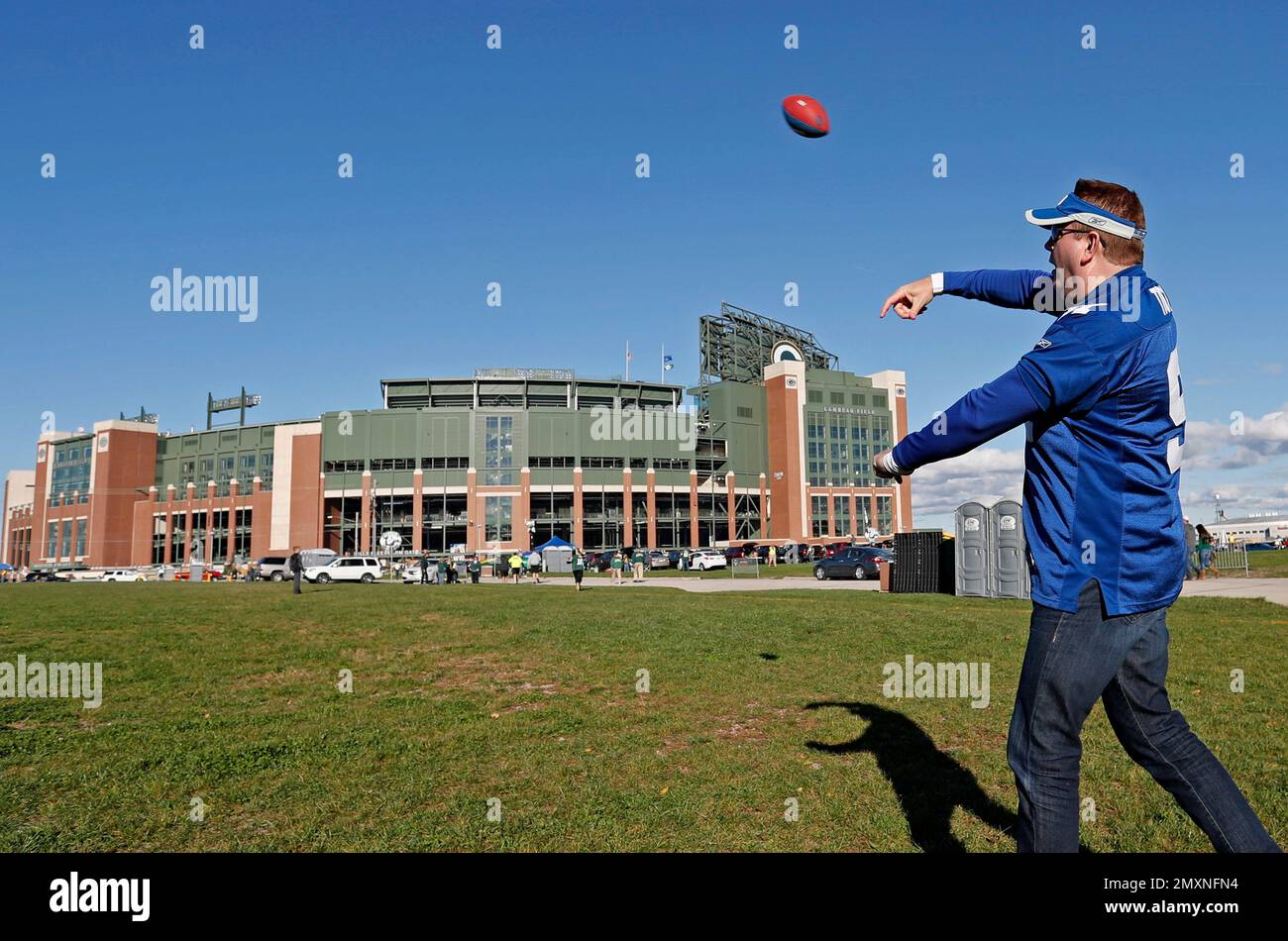 New York Giants fan Tom Leddy throws a football outside Lambeau Field ...