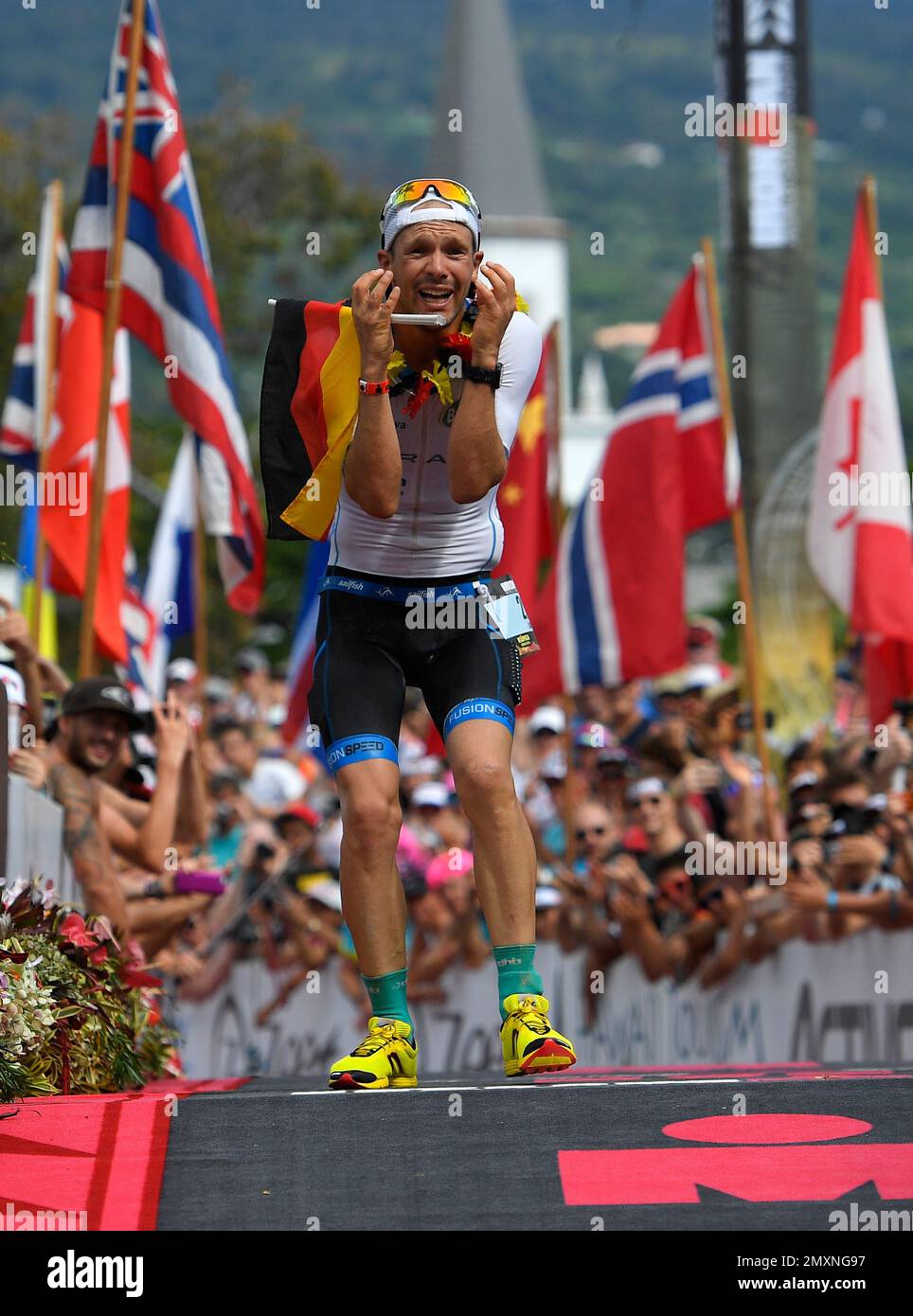 Patrick Lange, of Germany, celebrates as he takes third in the Ironman ...
