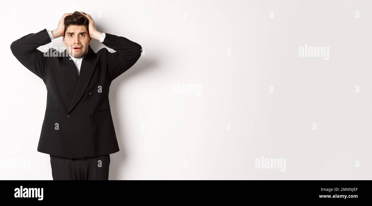 Frustrated and worried businessman in black suit, panicking as looking ...