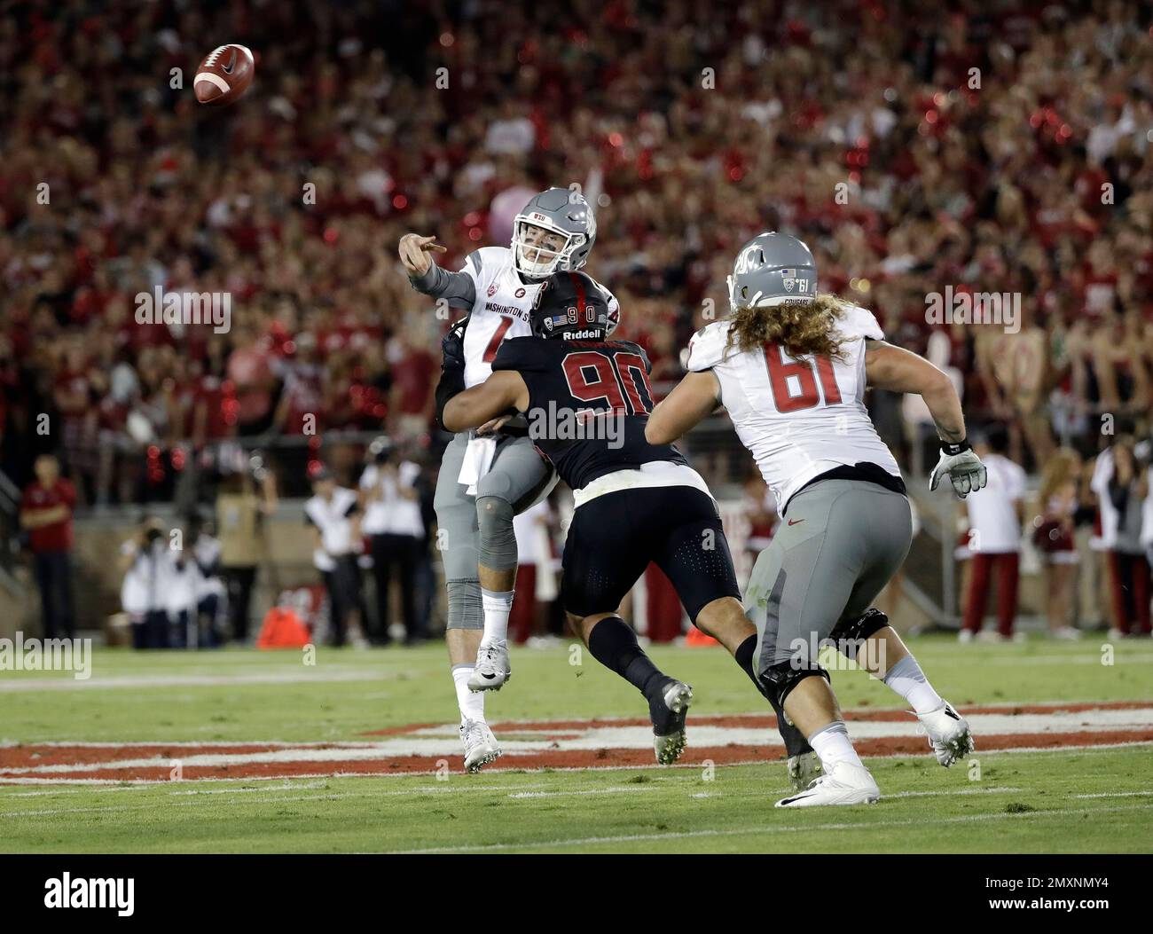 Washington State quarterback Luke Falk, left, throws under pressure ...