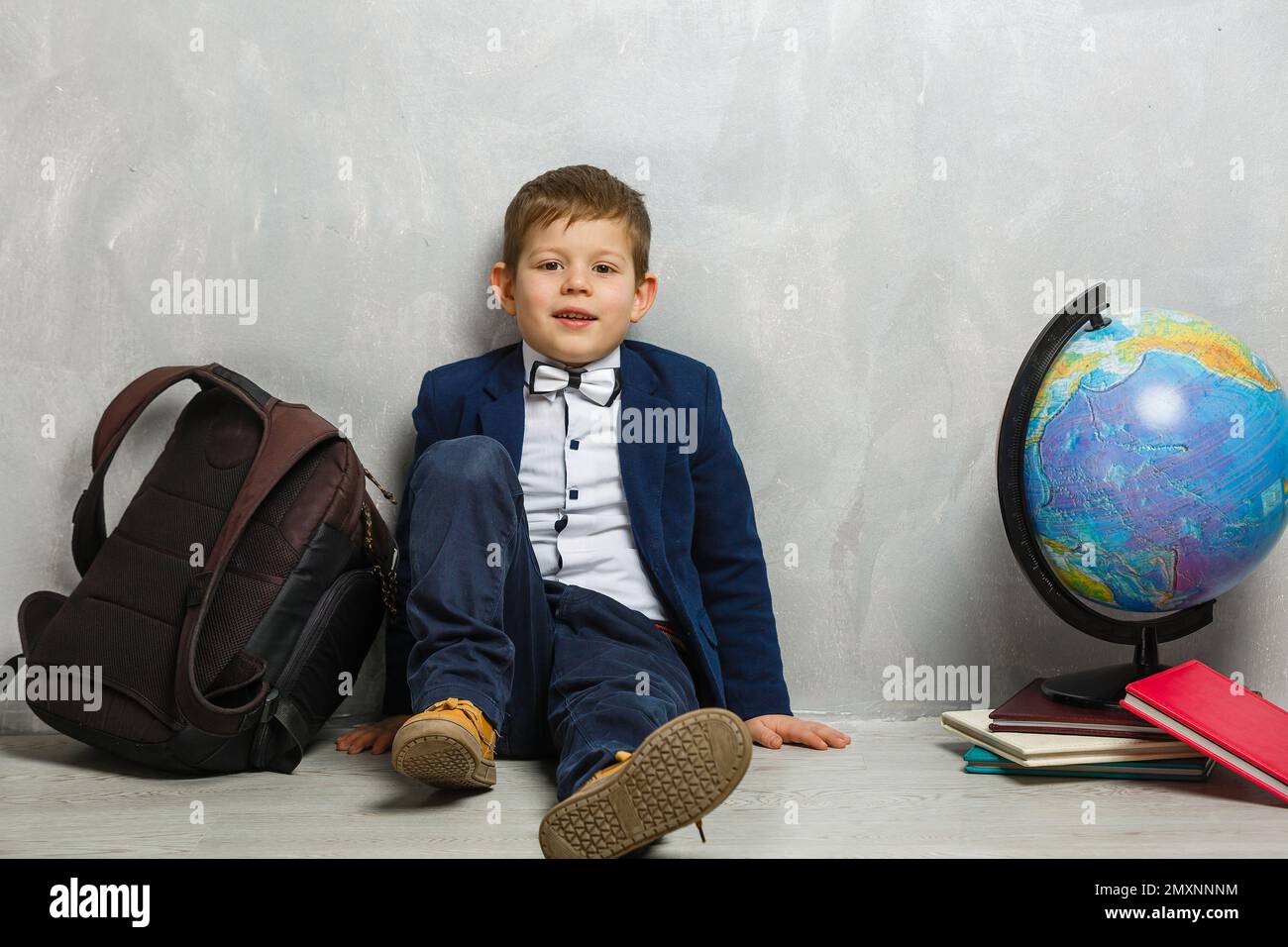 Happy cute clever boy in glasses with school bag and book. Modern ...