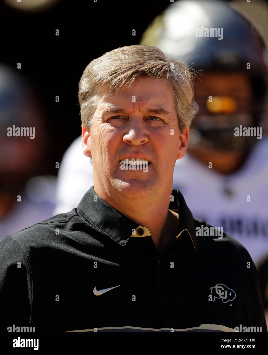 Colorado head coach Mike MacIntyre leads his players onto the field ...