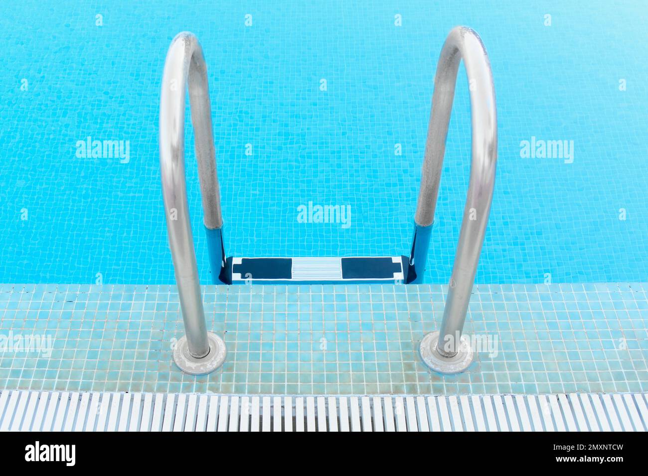 Pool ladder somewhat deteriorated by pool products in the foreground ...