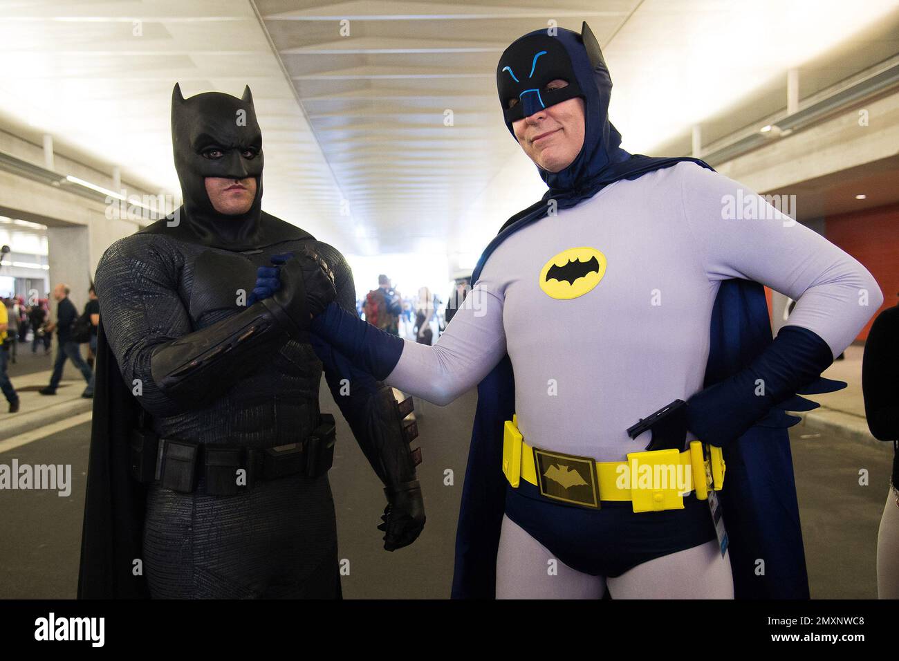 Attendees dressed as different versions of Batman walk the floor of New ...