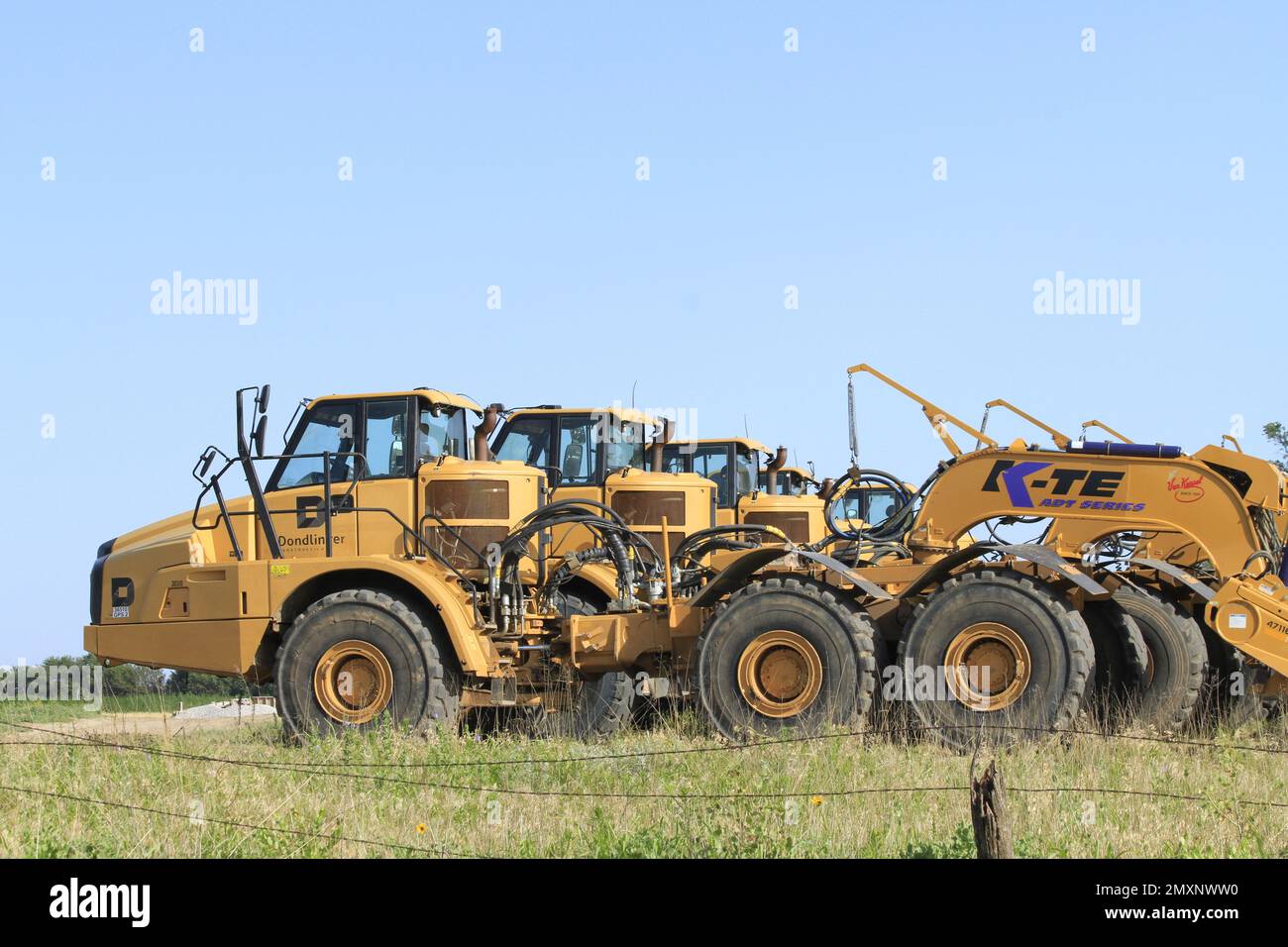 Heavy Equipment Scrapers with blue sky and grass Stock Photo - Alamy