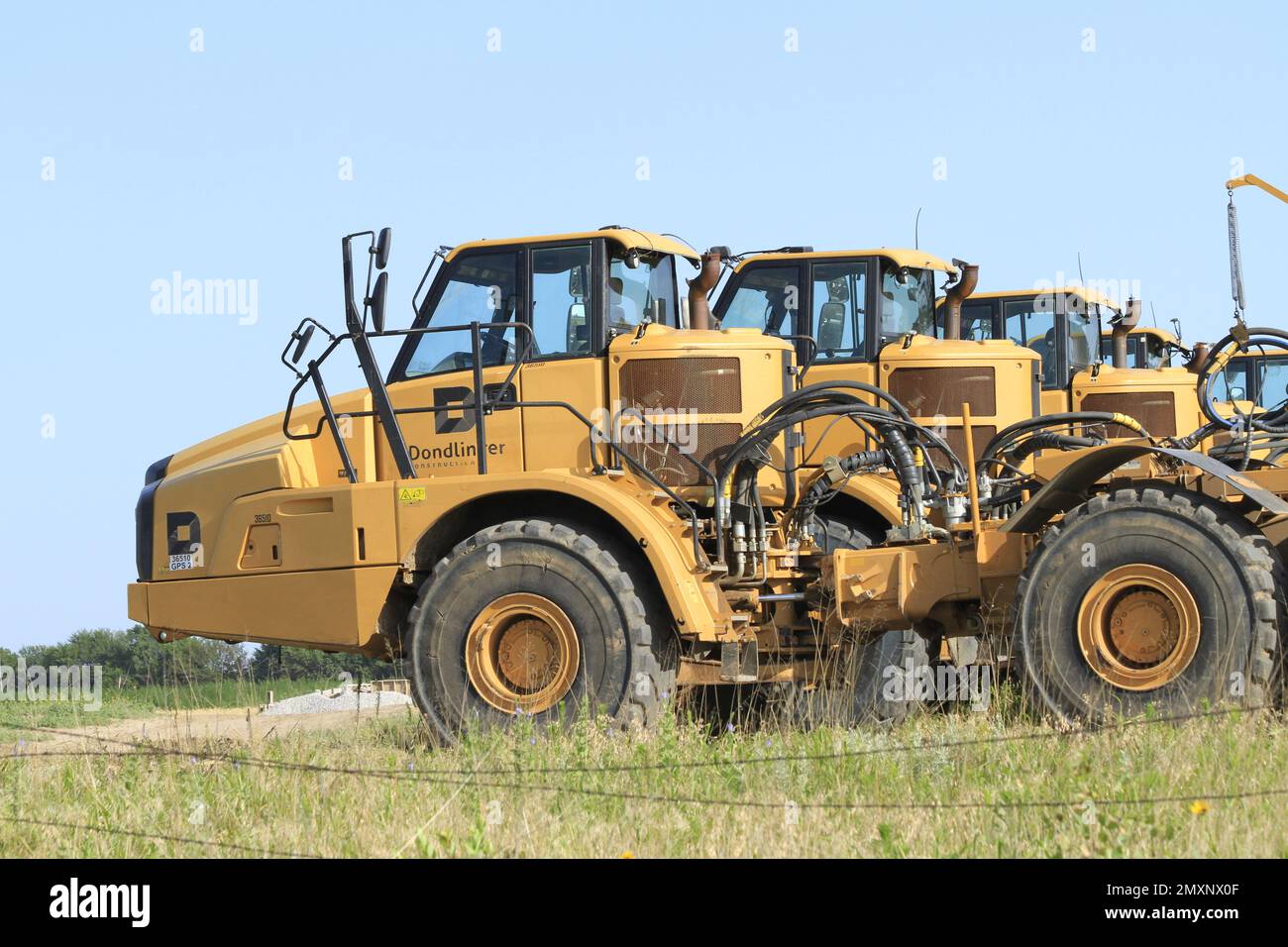 Heavy Equipment Scrapers with blue sky and grass Stock Photo - Alamy