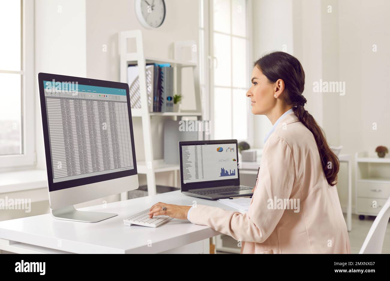 Side view of a girl making audit, accounting or financial report ...