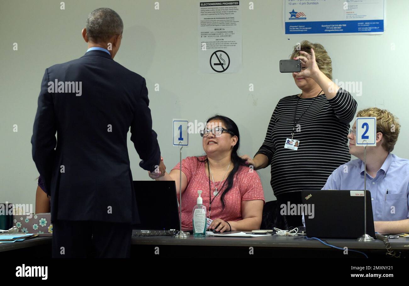 President Barack Obama checks in with poll workers to cast his ballot ...