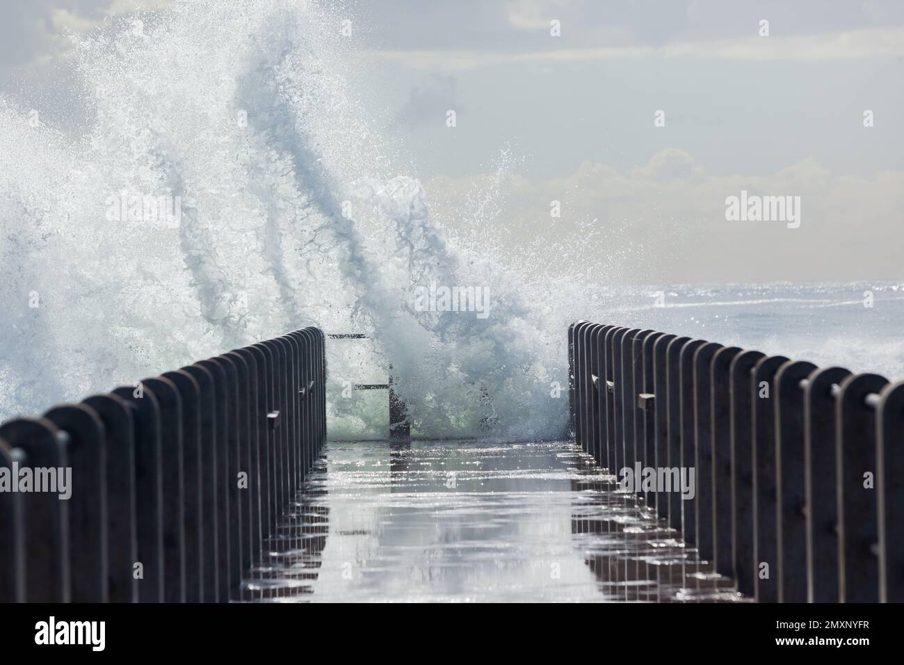 Wave ocean power water exploding front of beach pier jetty walking path ...