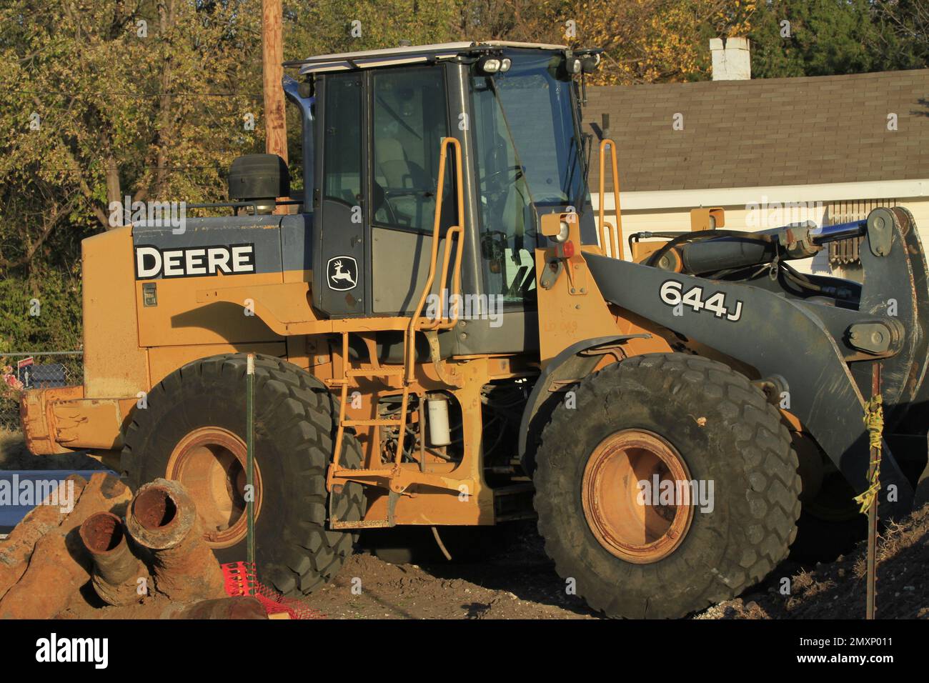A John Deere Wheel Loader at a work site with trees Stock Photo - Alamy