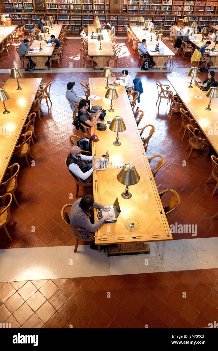 People sit at the long desks in the Rose Main Reading Room of the New ...