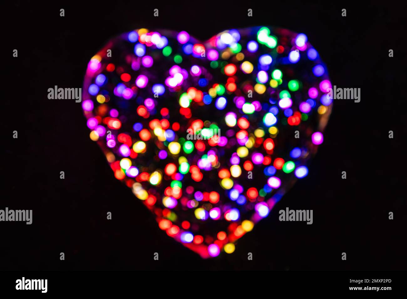 Multicolored defocused circles from the light in the shape of a heart ...
