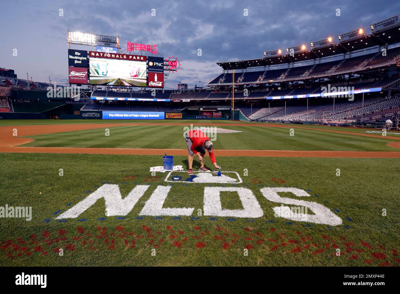 Washington Nationals field manager Matt Coates paints the NLDS logo on ...