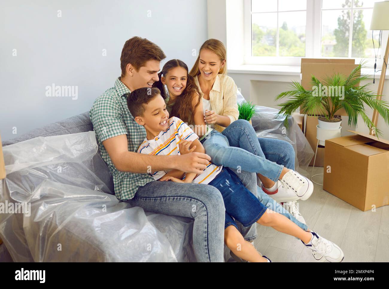 Happy smiling family with children are moving in new modern house ...