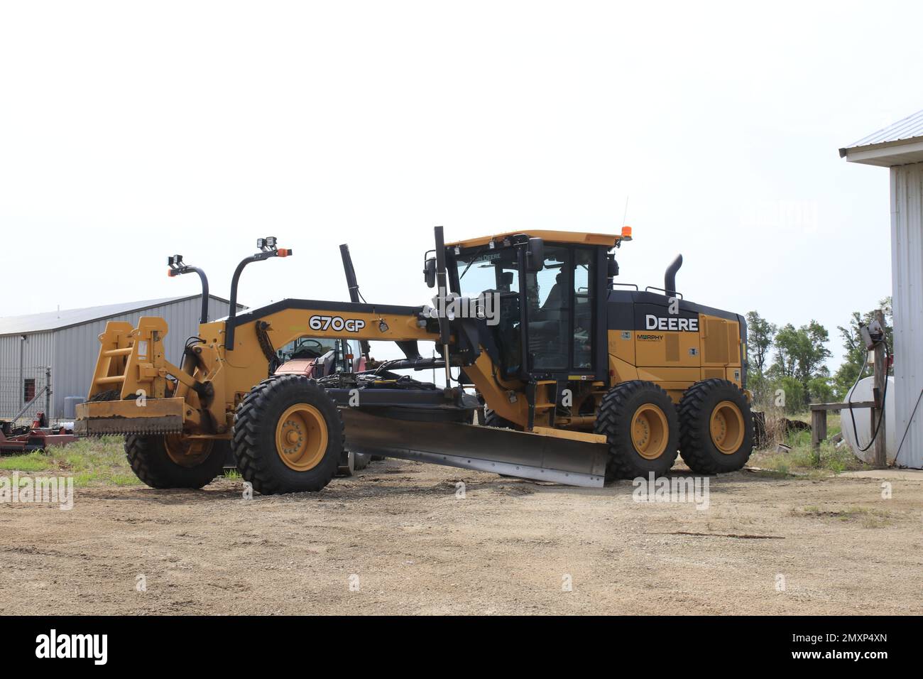 John Deere road grader with sky and shop building Stock Photo - Alamy