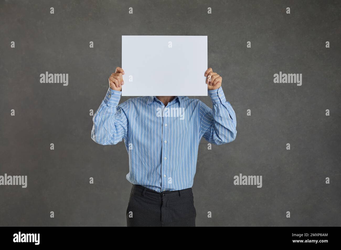 Anonymous businessman covering his face hiding behind white mockup ...