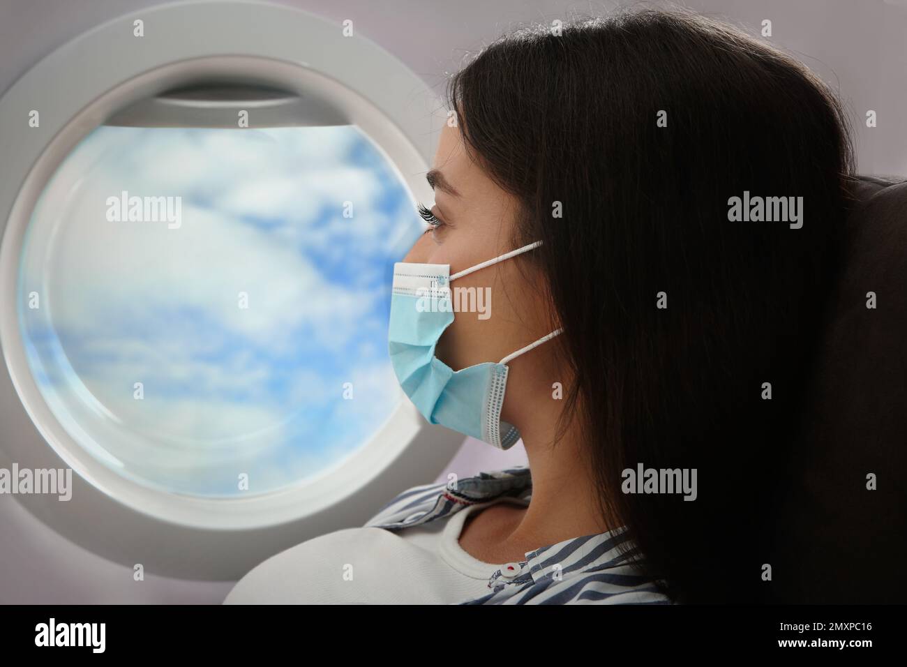 Traveling by airplane during coronavirus pandemic. Woman with face mask ...