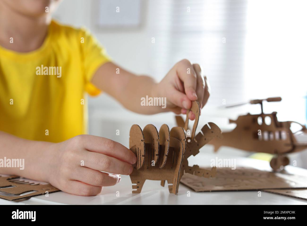 Little boy making carton toys at table indoors, closeup. Creative hobby ...