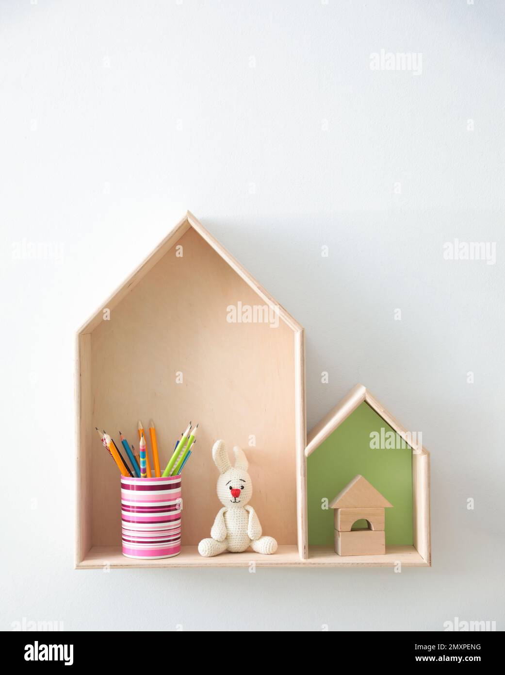 Different house shaped shelves with toys on white wall. Interior design ...