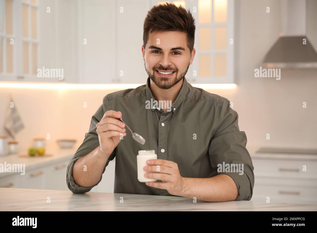 Man eating yogurt sitting table hi-res stock photography and images - Alamy