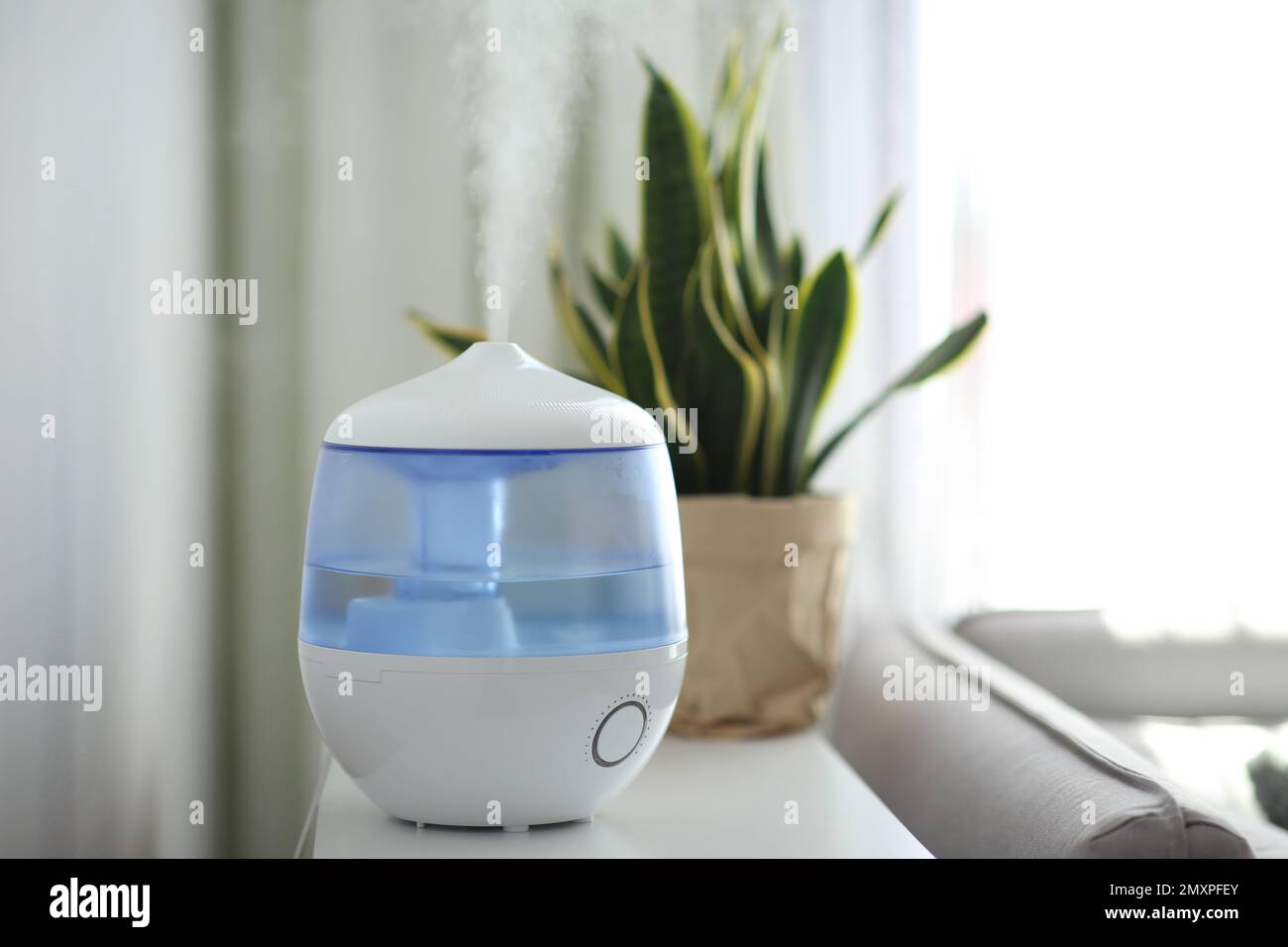 Modern air humidifier on table in living room. Space for text Stock ...