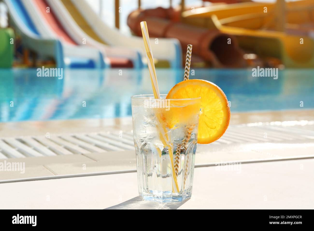 Glass of refreshing drink near swimming pool Stock Photo - Alamy