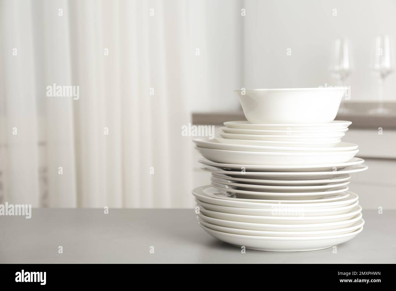 Stack of clean plates on grey table in kitchen. Space for text Stock ...