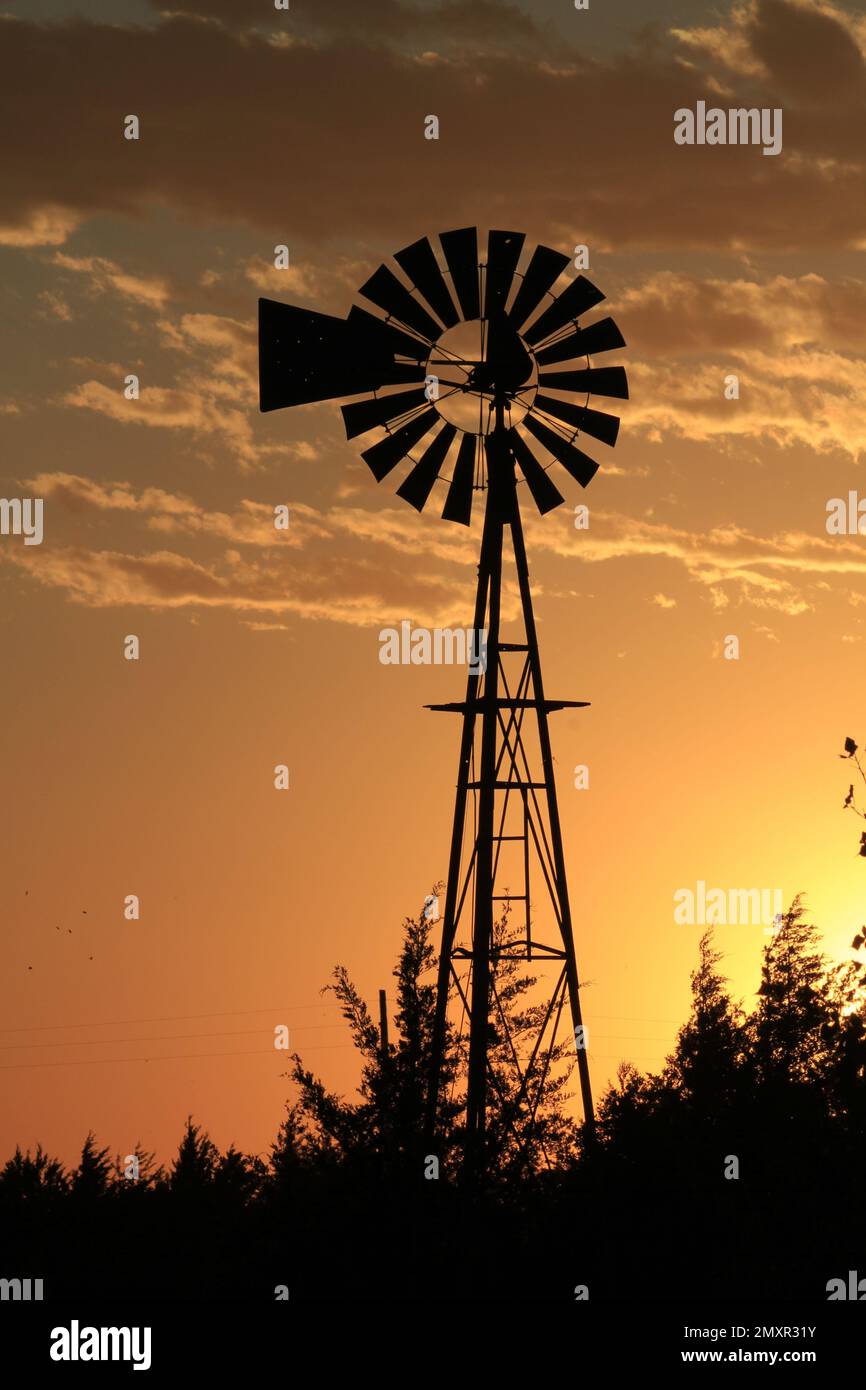 Kansas Windmill Silhouette with a colorful sky and clouds Stock Photo ...