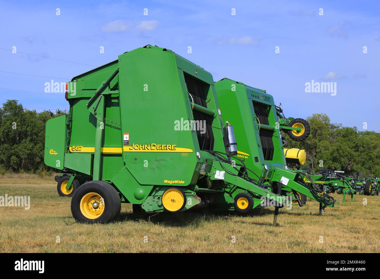 John Deere Baler with green grass and blue sky Stock Photo - Alamy