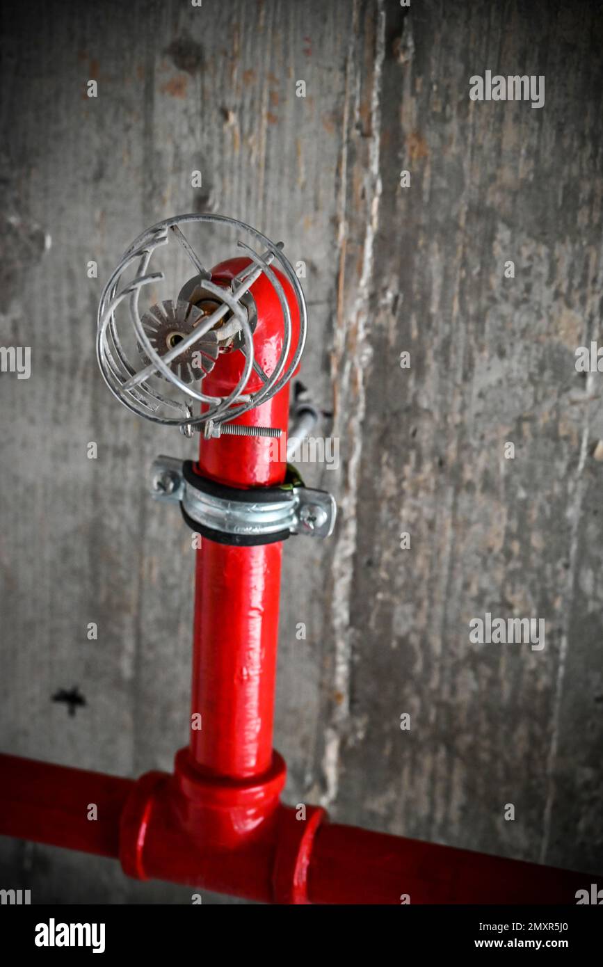 A detail of a rustic ceiling with red pipes and a fire alarm Stock ...