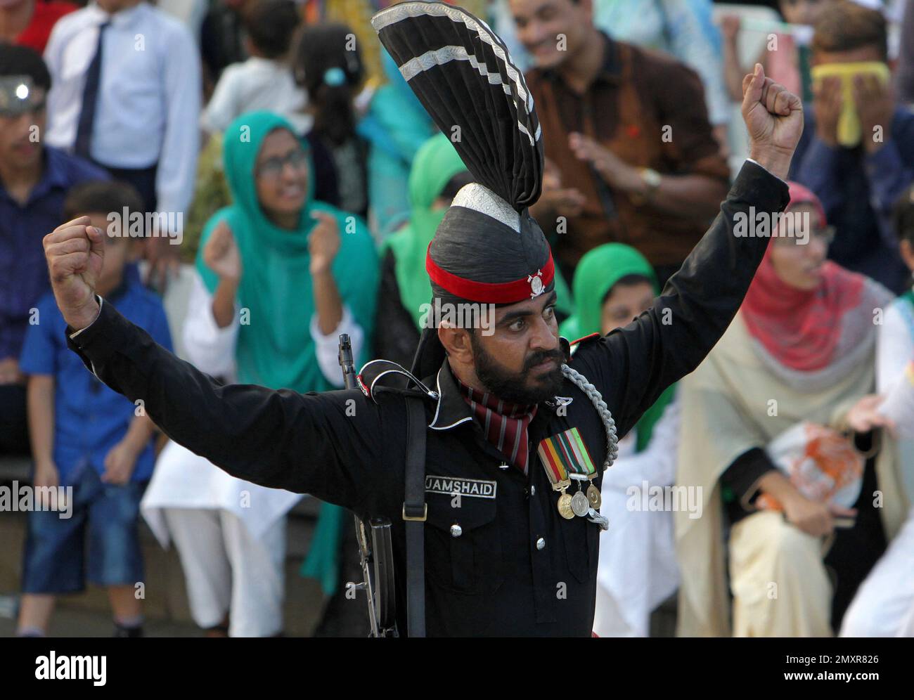 A Pakistani border guard gestures while looking towards his Indian ...