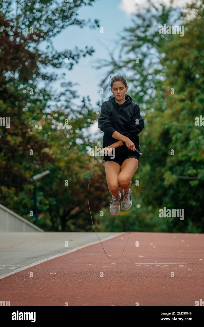 Girl jumping rope. Twirl the rope from left to right Stock Photo - Alamy