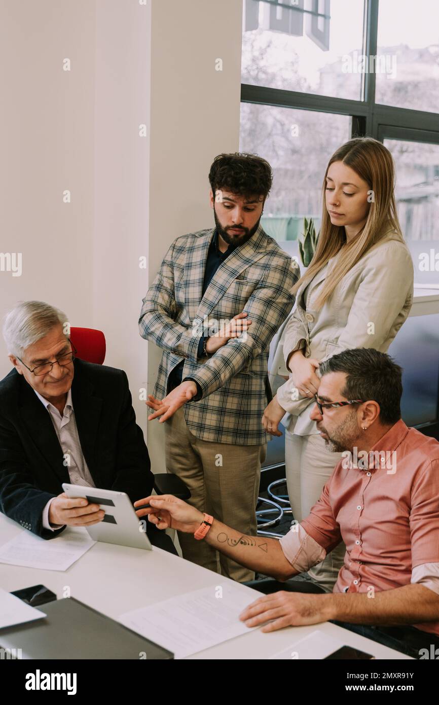A young junior business person giving a proposition to his senior ...