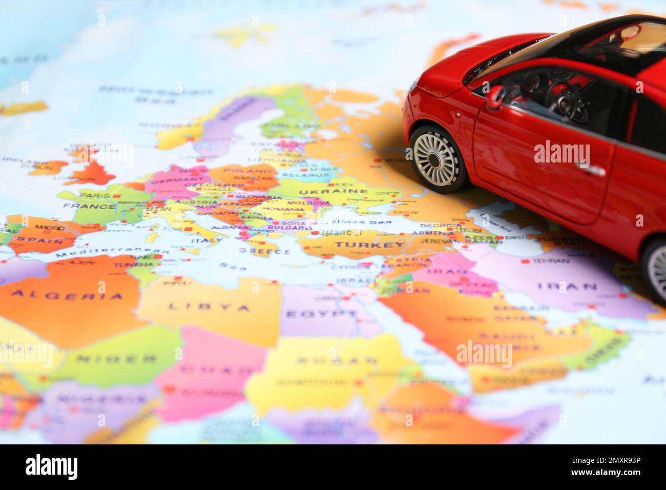 Red toy car on world map, closeup. Trip planning Stock Photo - Alamy