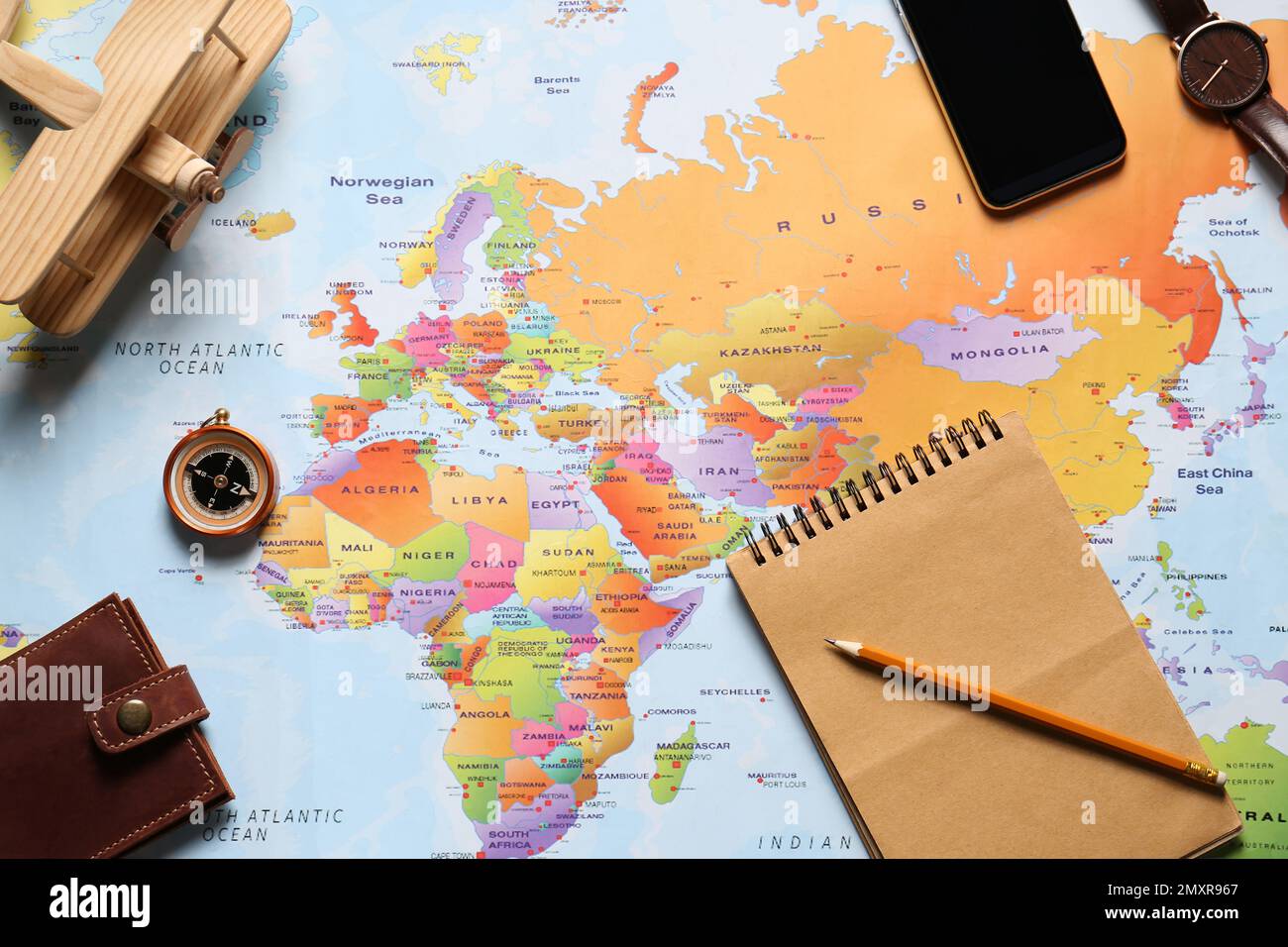 Flat lay composition with notebook and different items on world map ...