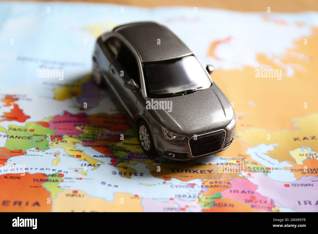 Grey toy car on world map. Trip planning Stock Photo - Alamy