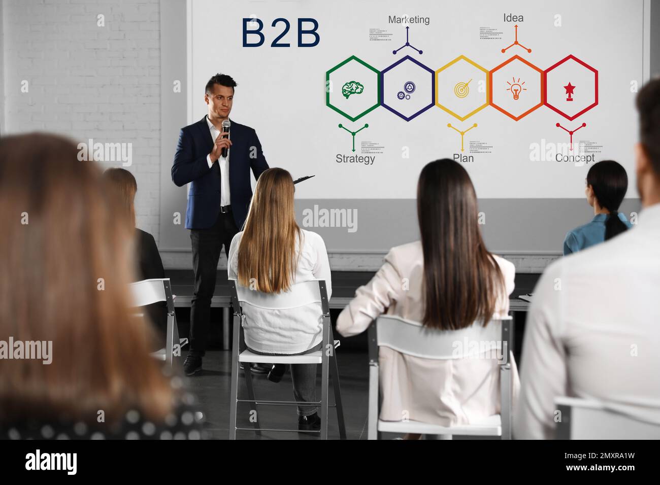 Business trainer giving lecture in conference room with projection ...