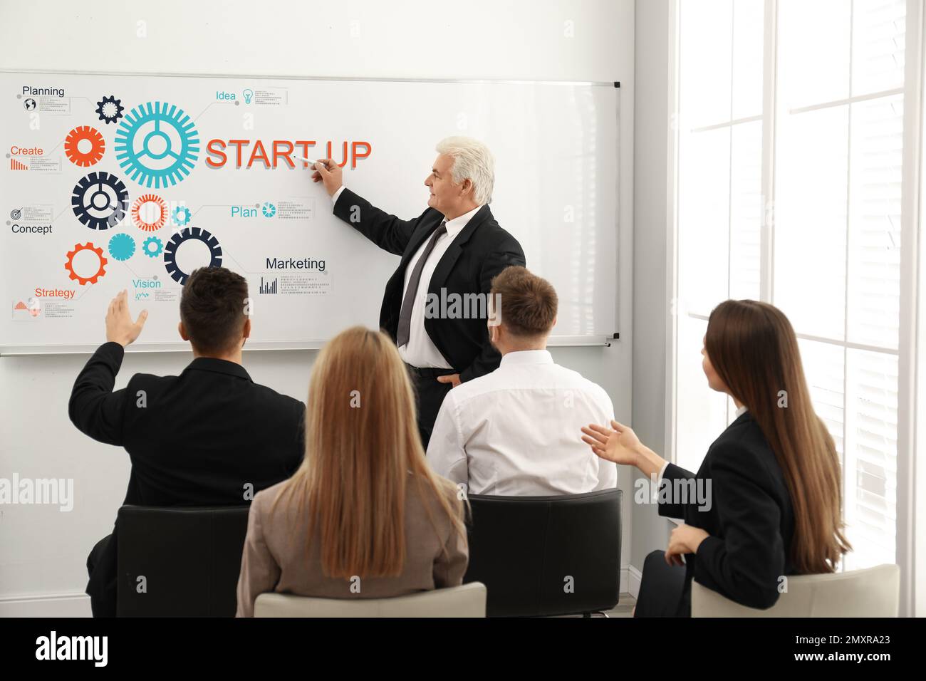 Business trainer giving lecture in conference room Stock Photo - Alamy