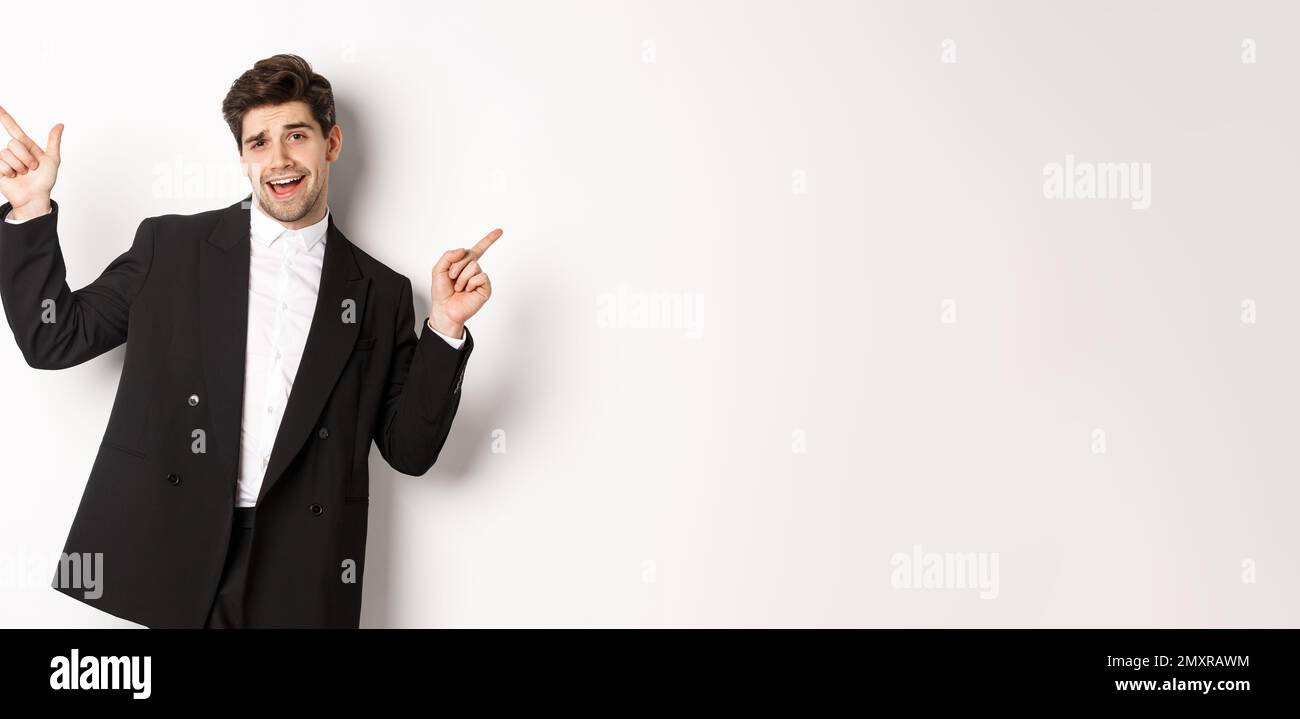 Handsome guy dancing and partying in black suit, pointing fingers ...