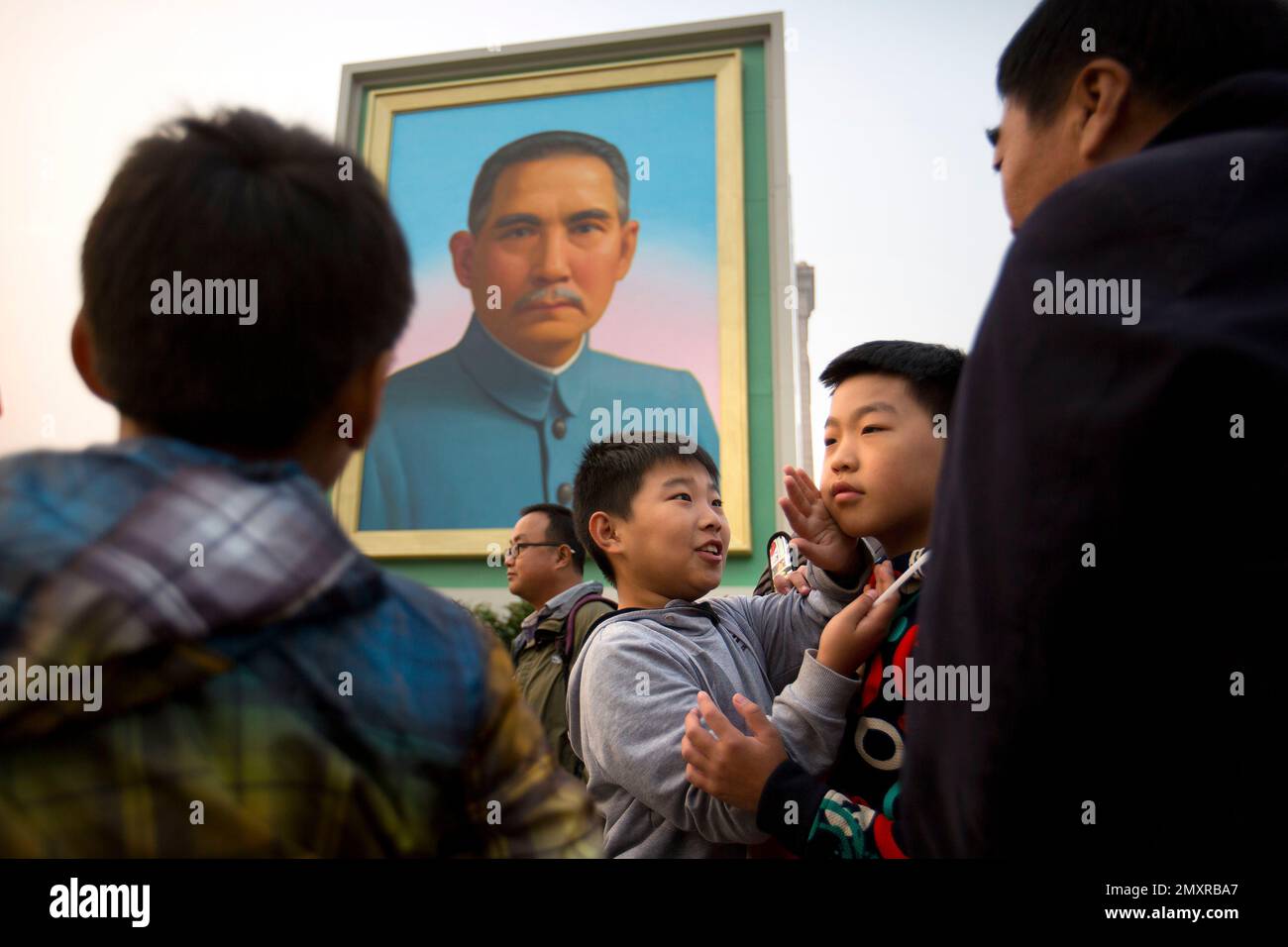 Children play in front of a portrait of Sun Yat-sen, who is widely ...