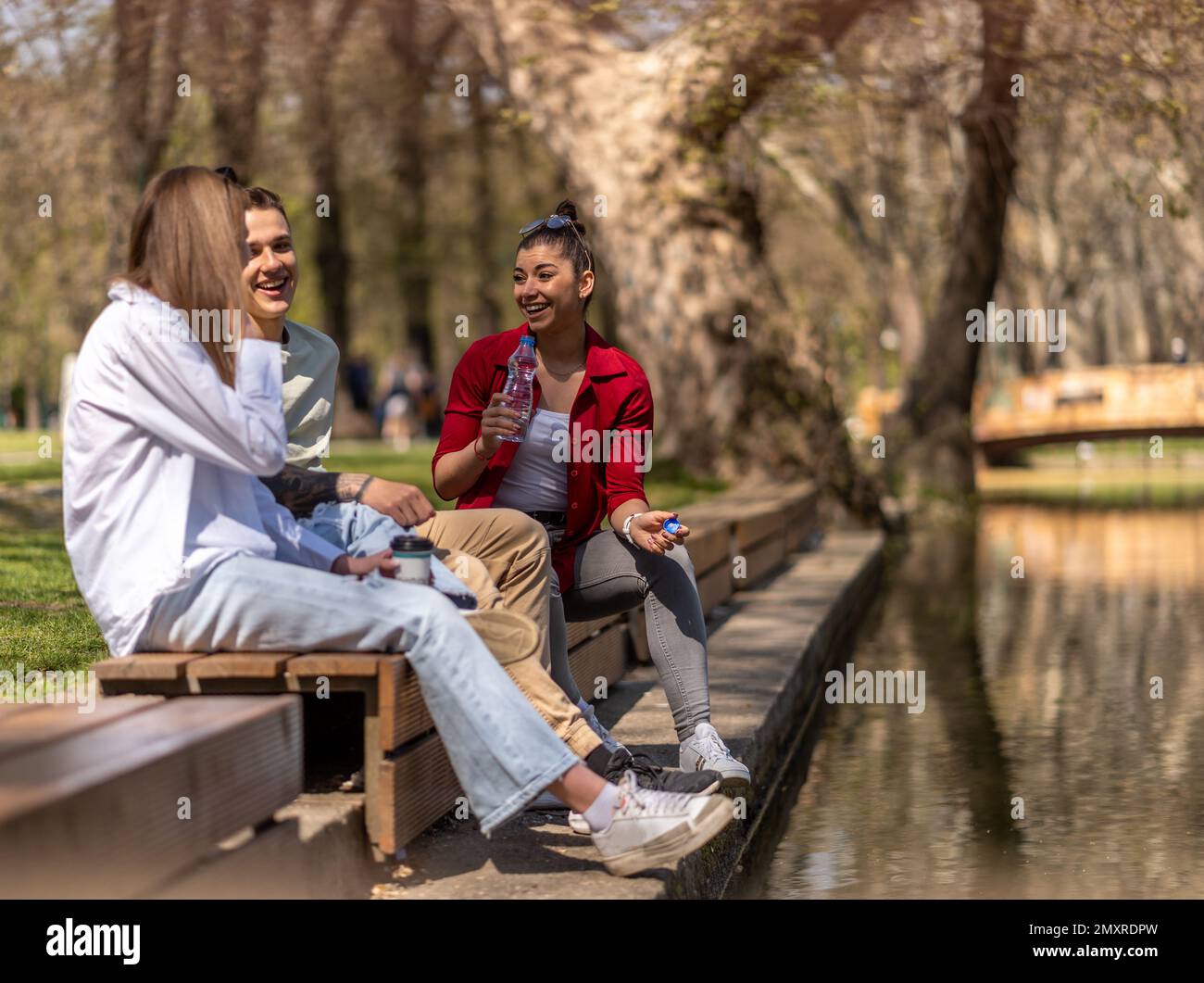 Full length portrait of cheerful college student talking to friends ...