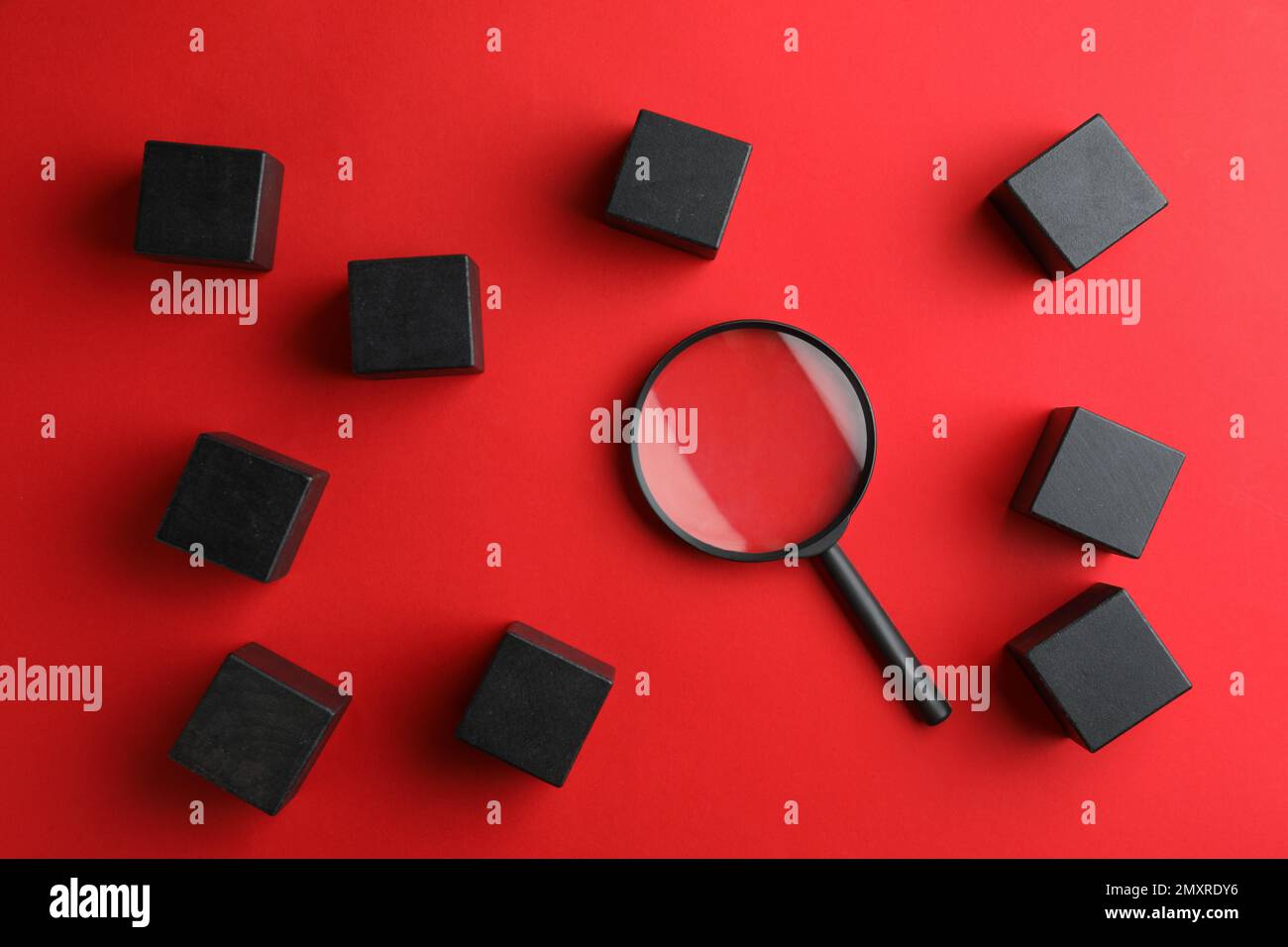 Black cubes and magnifier glass on red background, flat lay. Find ...
