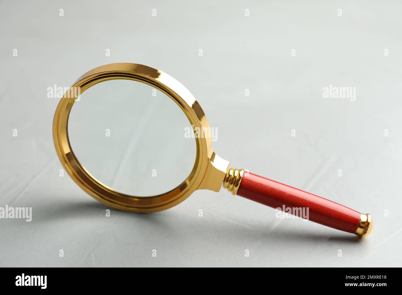 Magnifier glass on light grey stone background, closeup. Find keywords ...