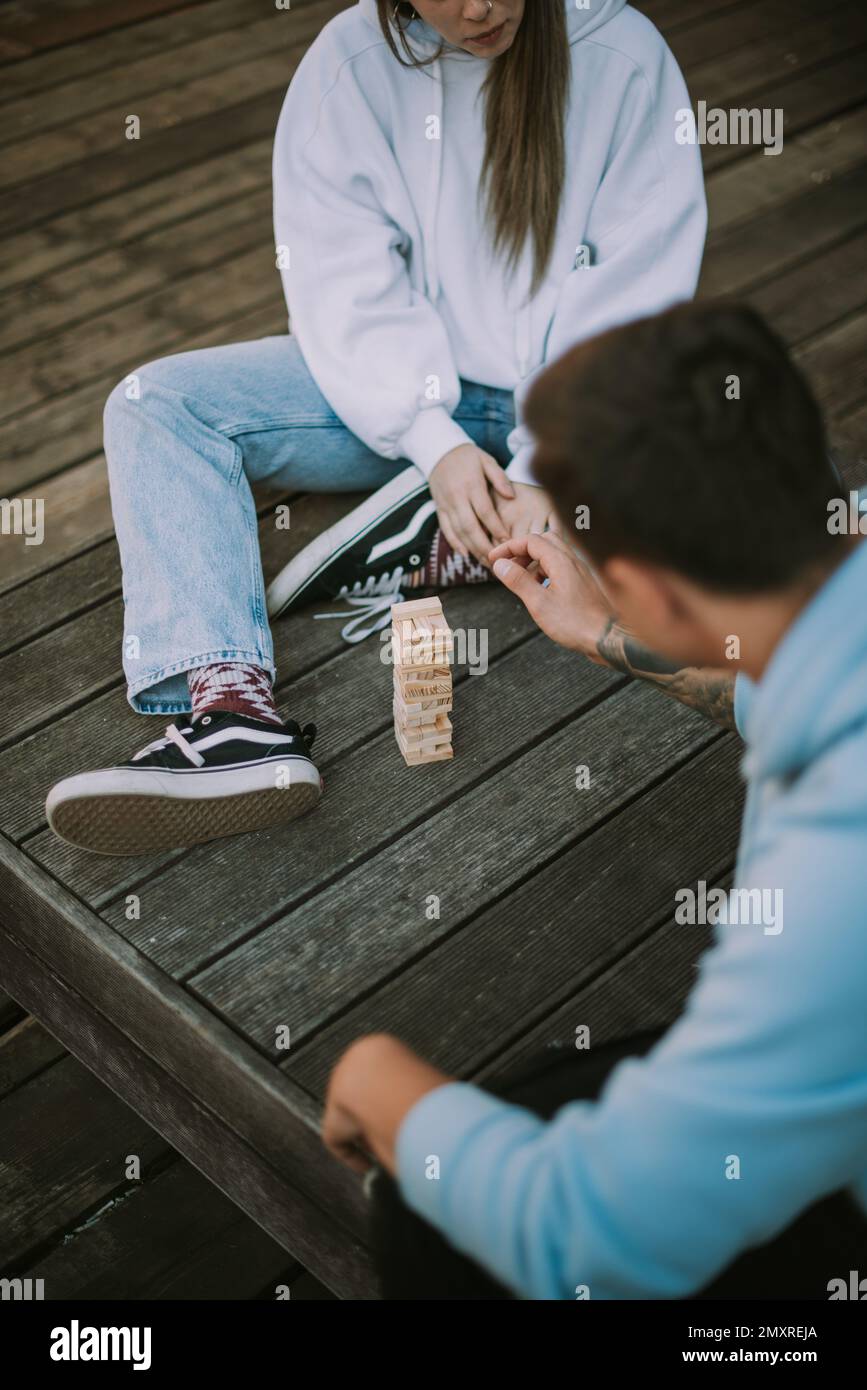 Close up of two friend playing jenga at the wooden bench Stock Photo ...